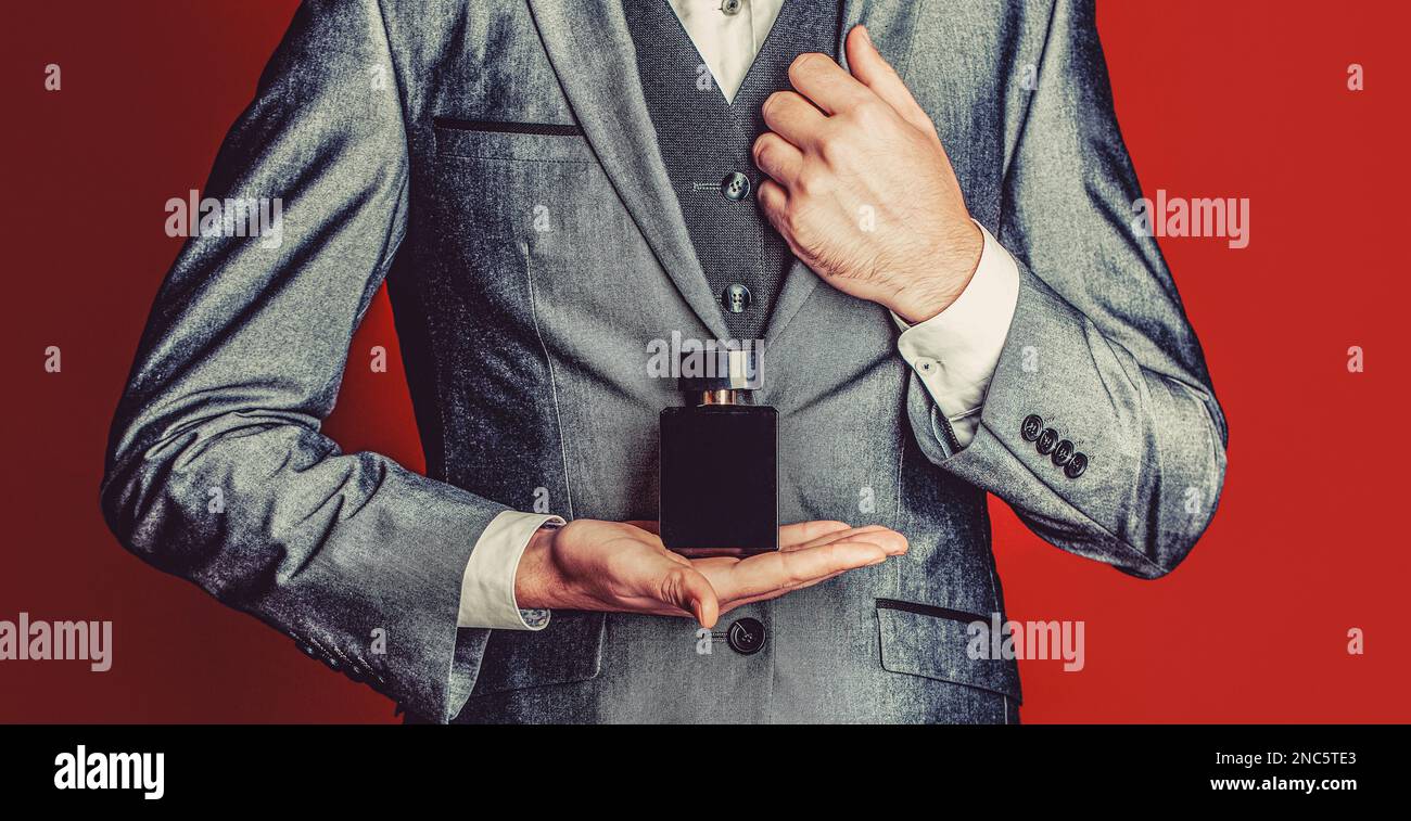 Man in formal suit, bottle of perfume, closeup. Men perfume in the hand ...