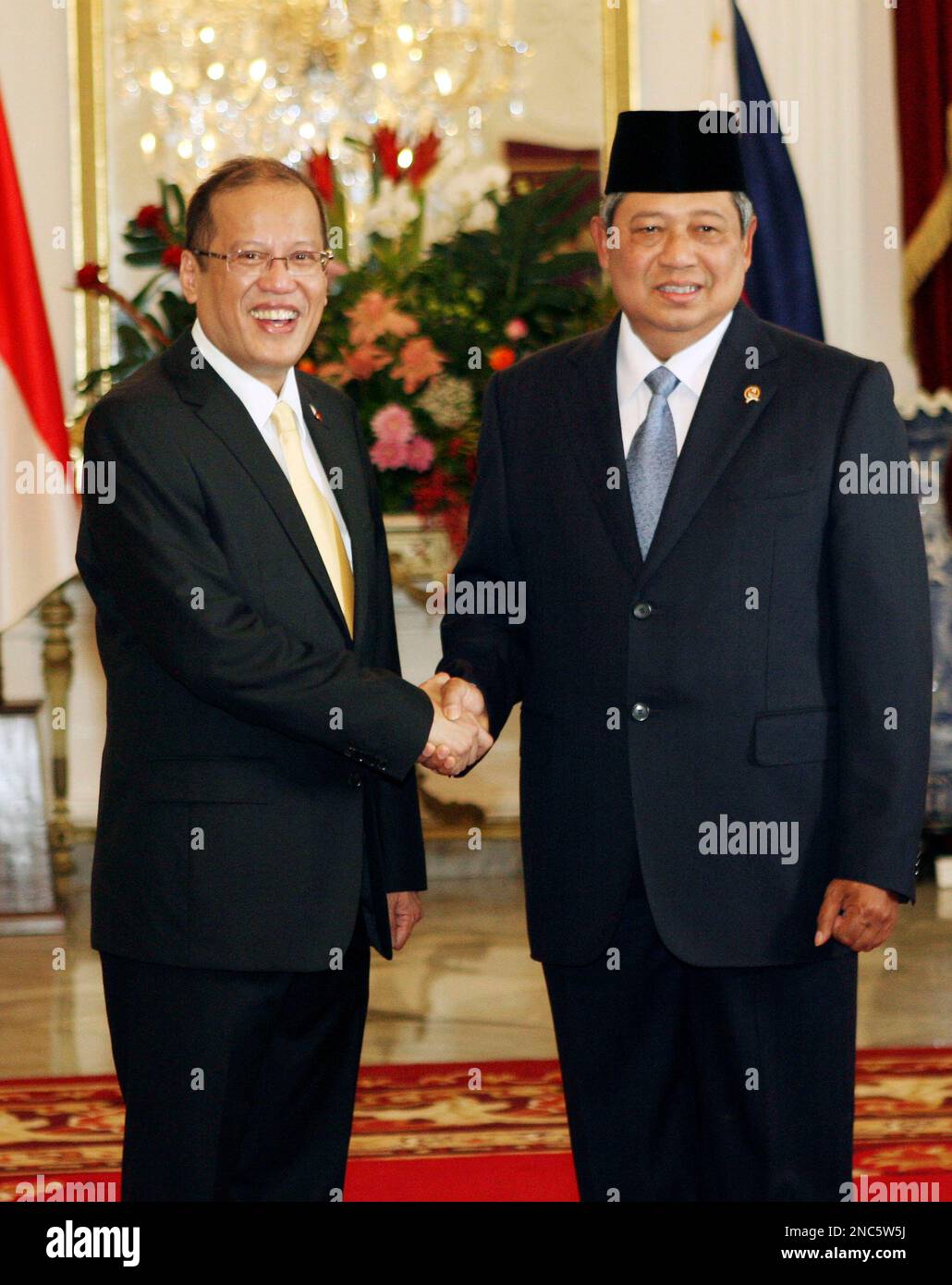 Philippine President Benigno Aquino III, left, shakes hands with ...