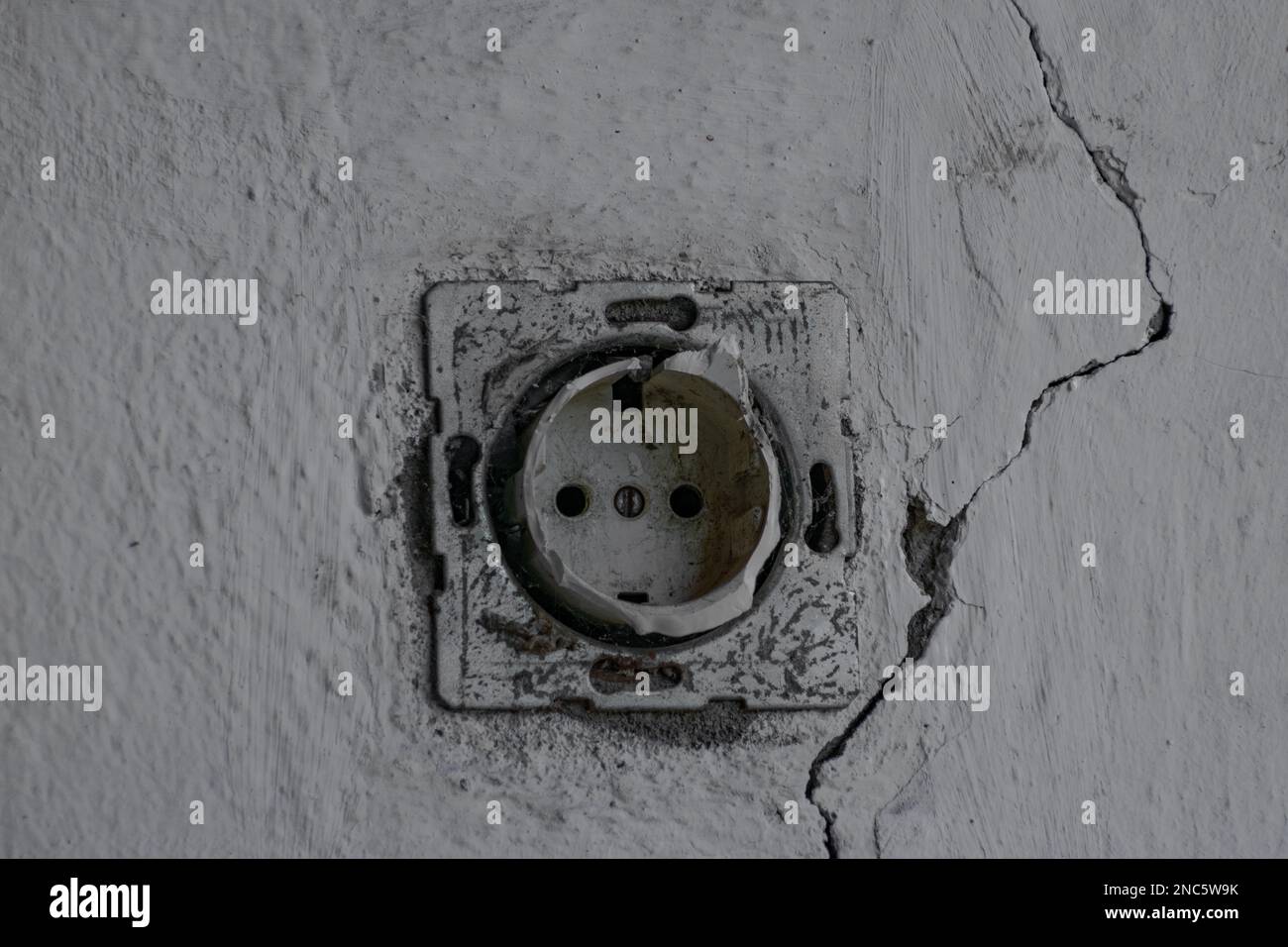 An old rusty electrical socket on a cracked white wall Stock Photo - Alamy