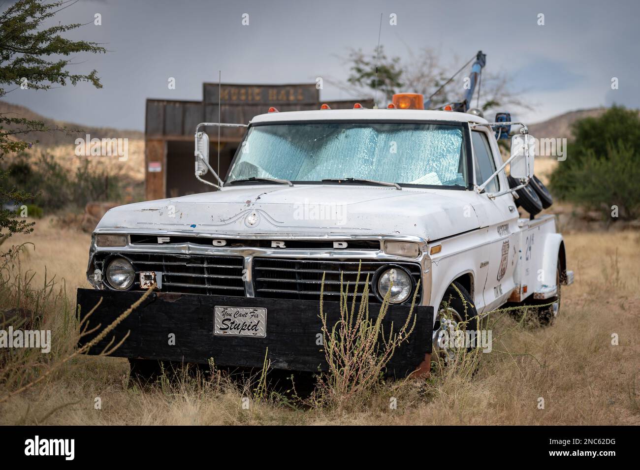 A white old abandoned sixth generation Ford F-Series tow truck on grass ...