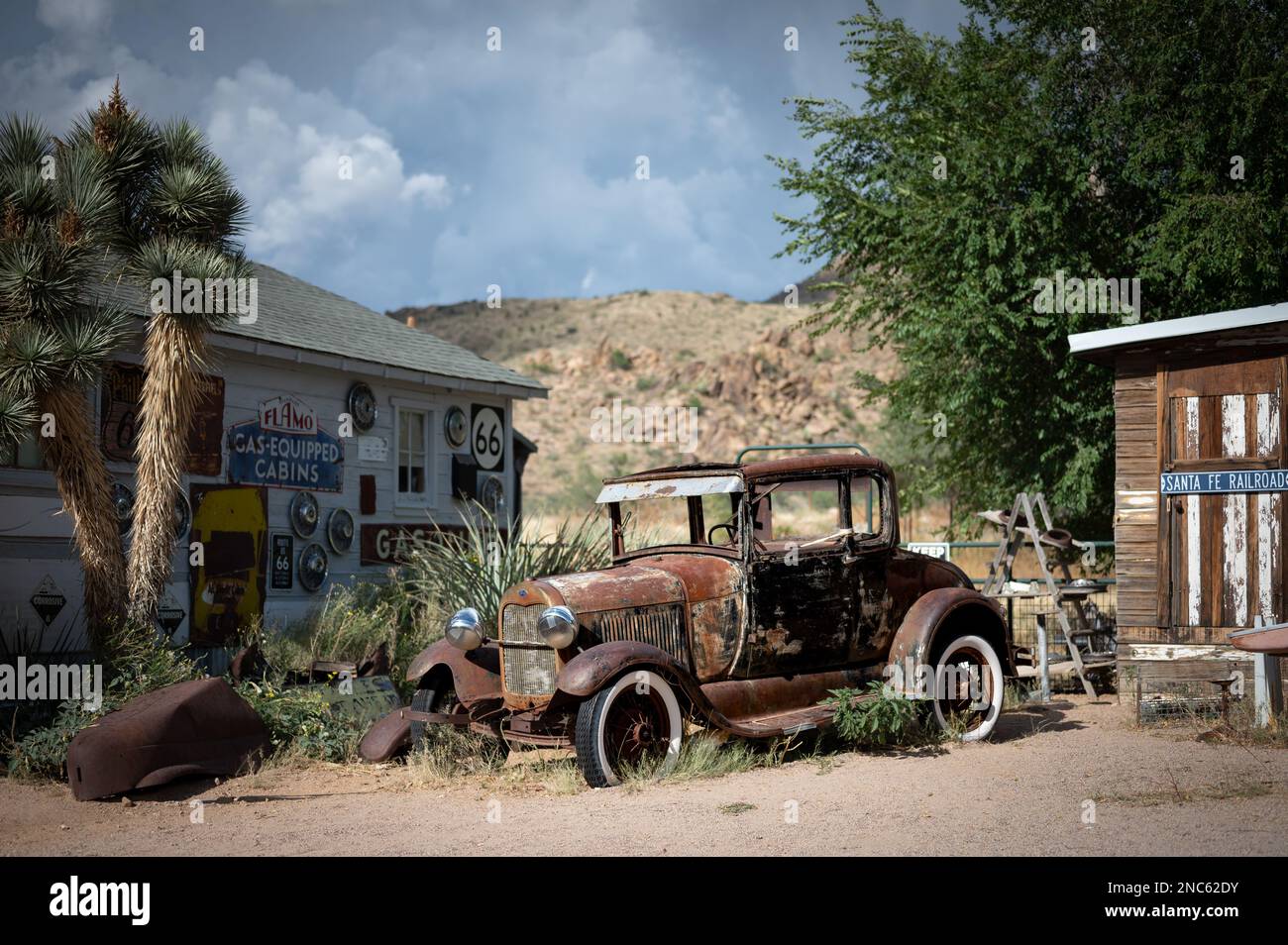 An Old abandoned Ford Model A in a remote town in the park with trees ...