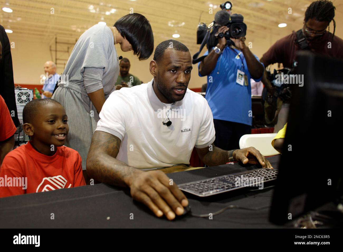 Miami Heat basketball player LeBron James, center, sits with Cam'ron ...