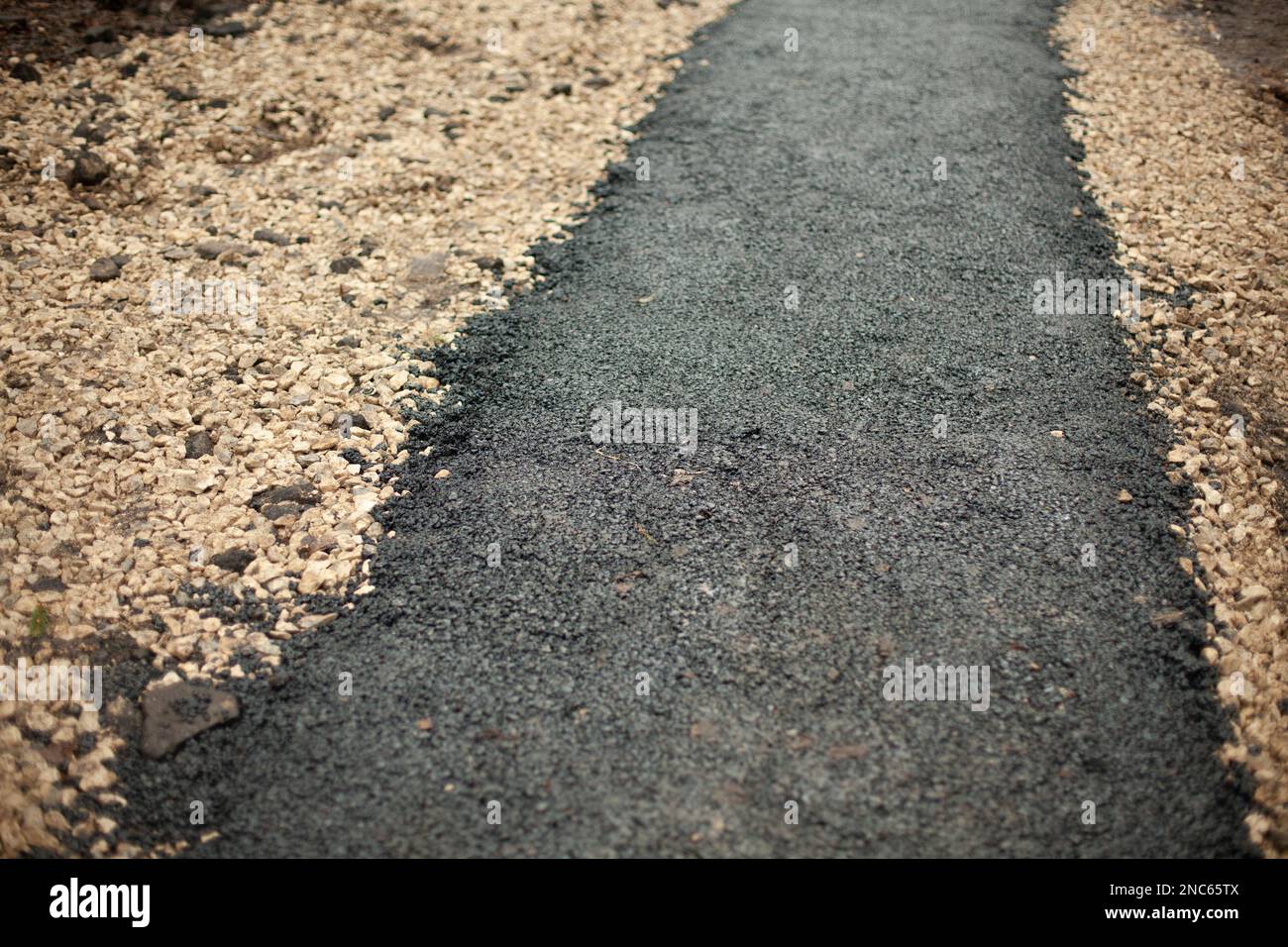 New asphalt. Construction of path in park. Details of road surface ...