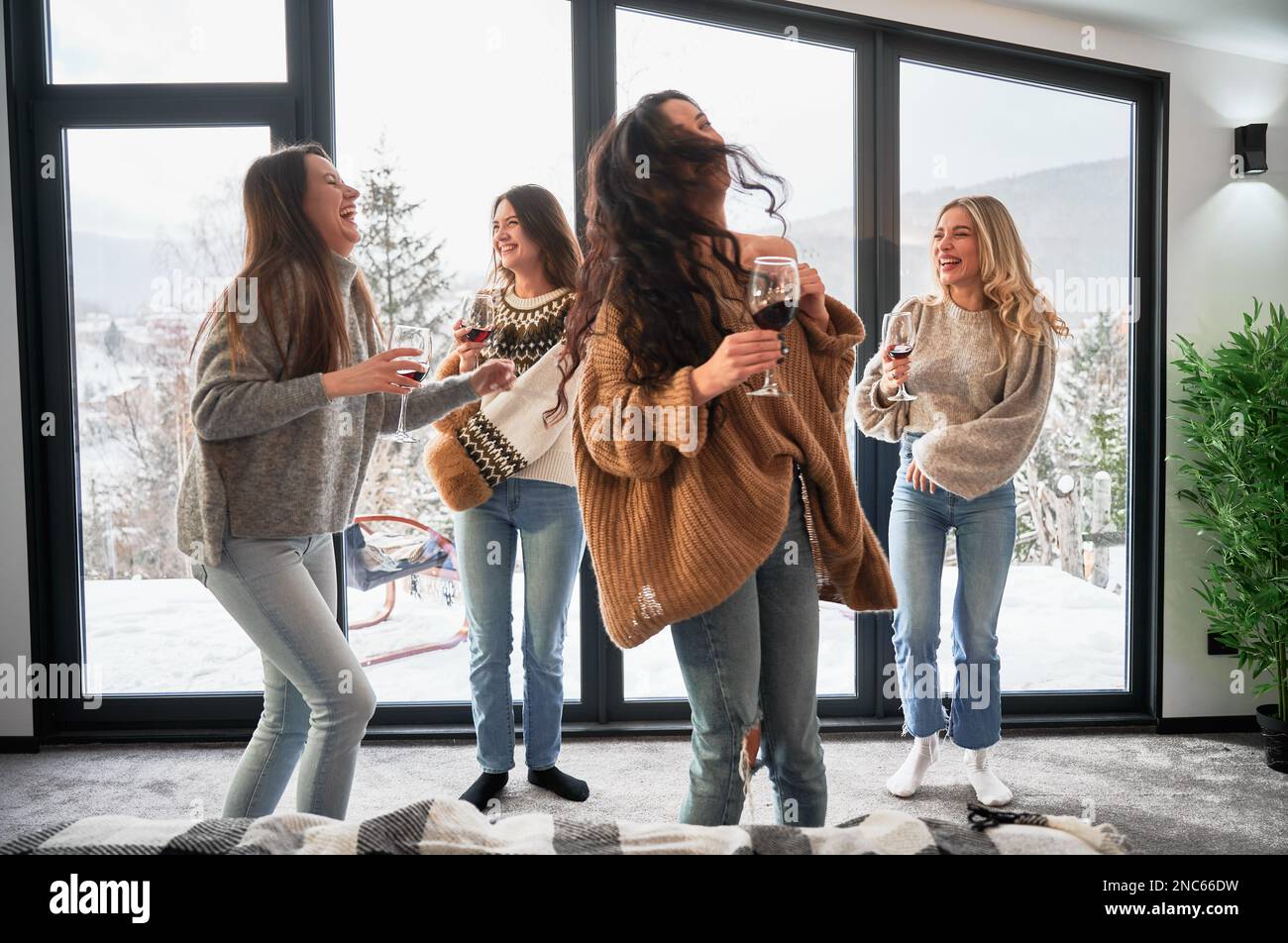 Young women enjoying winter weekends inside contemporary barn house ...