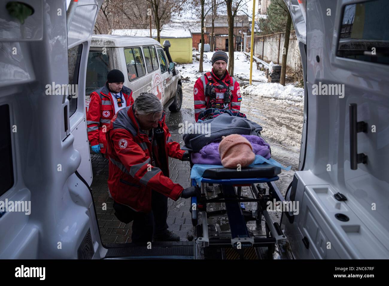 Red Cross volunteers load en elderly woman on a gurney during ...
