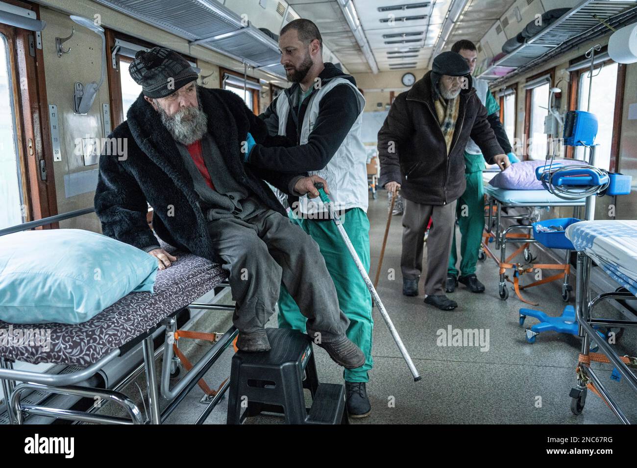 MSF workers help elderly men to take their seats inside MSF medical ...