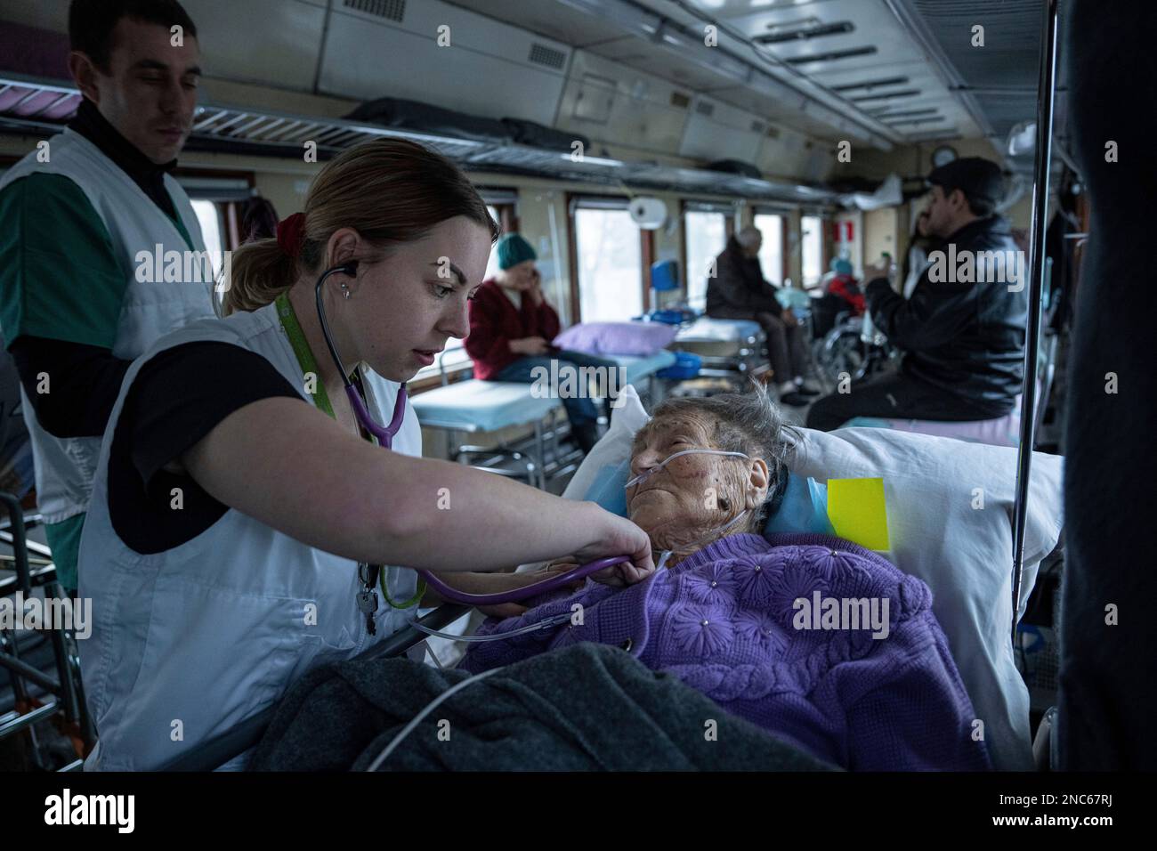 MSF medic worker treats an elderly woman inside the MSF medical train ...