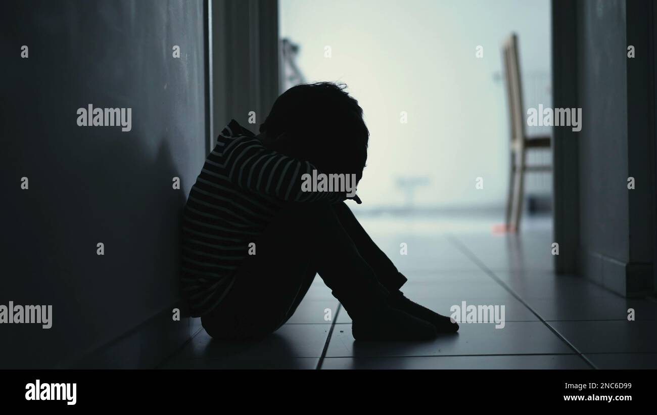 Sad child suffering from depression sitting alone in corridor feeling ...