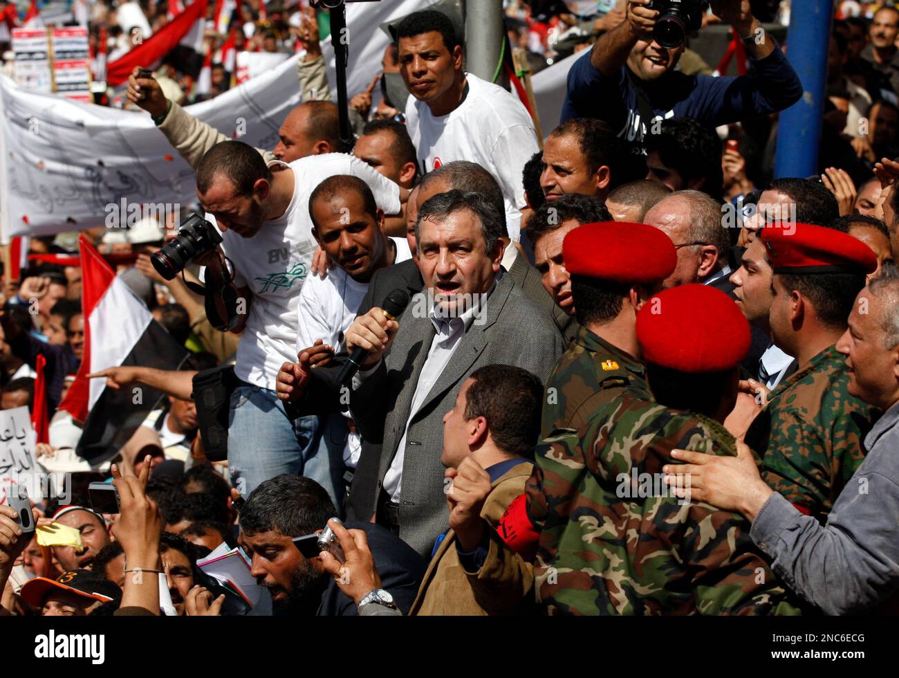 Egypt's new Prime Minister designate Essam Sharaf is surrounded by ...