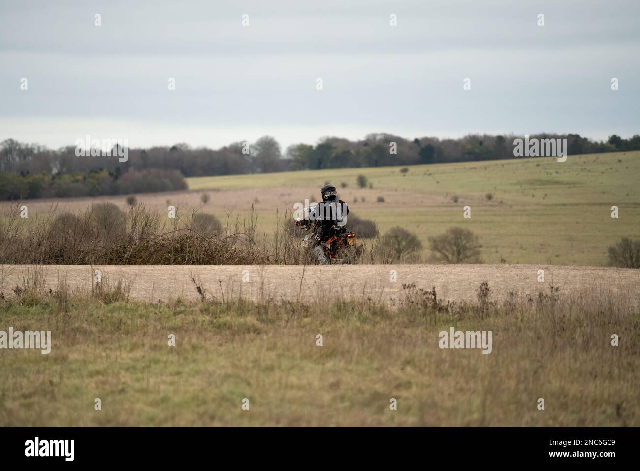 a motor cyclist (biker) riding their sports motorbike along a stone ...