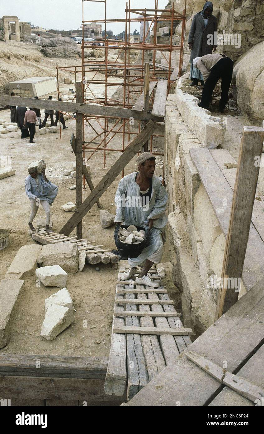 Workmen on scaffolding restore and add new stones to the giant Sphinx ...