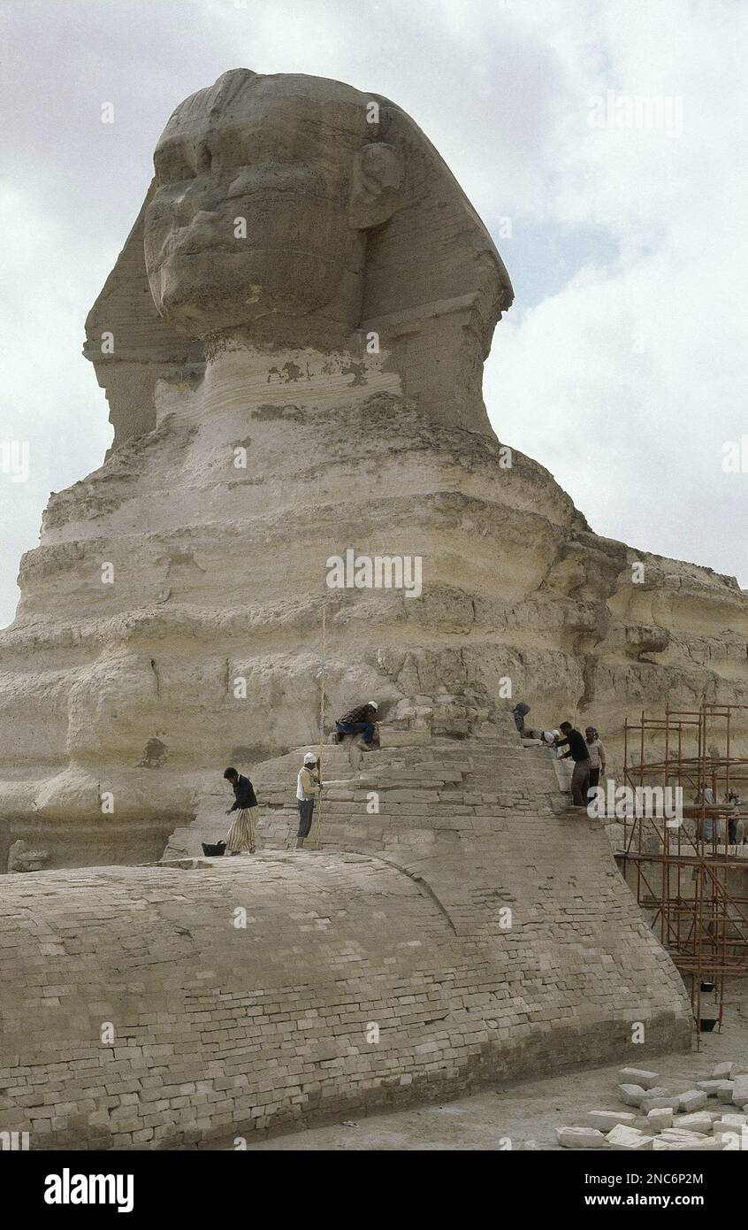 Workmen on scaffolding restore and add new stones to the giant Sphinx ...