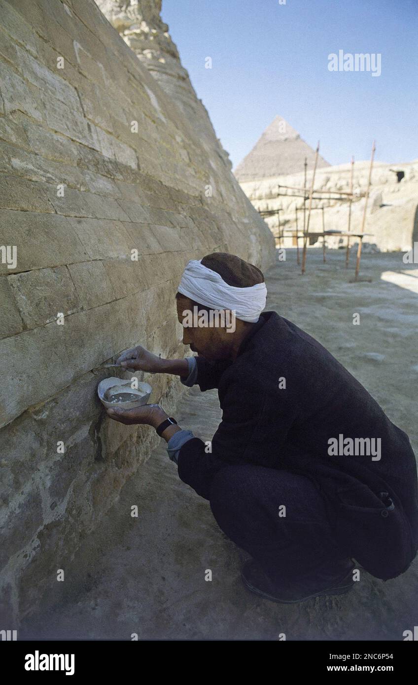 A workman packs mud on the limestone of the Sphinx in Giza, Egypt, this ...