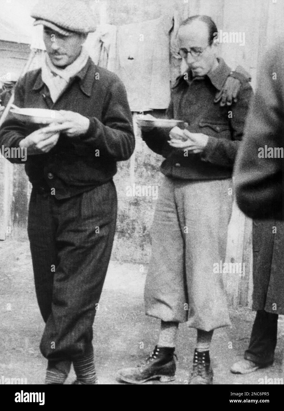 Frenchmen file past after receiving their food in a Nazi concentration ...