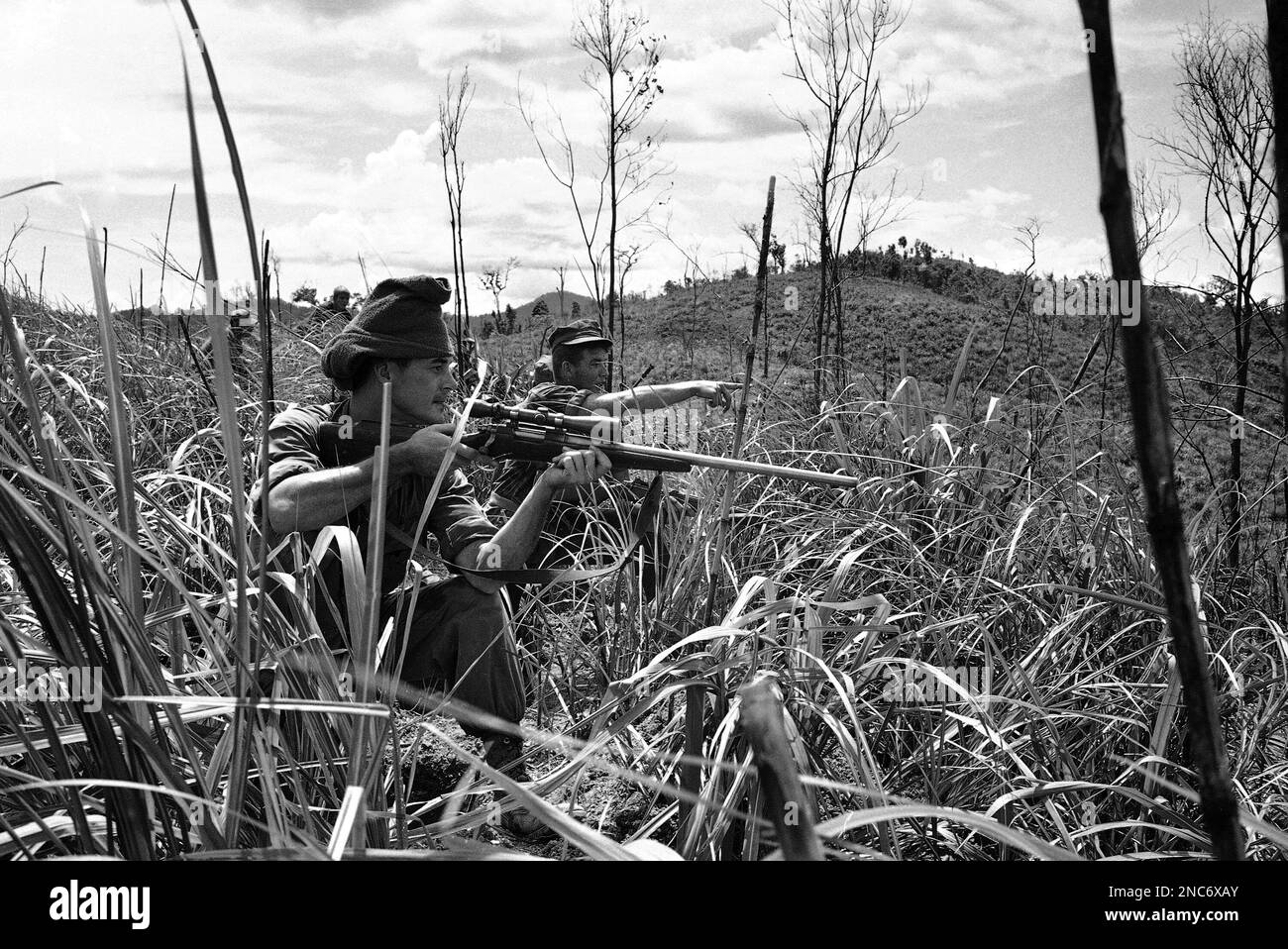 A U.S. Marine sniper and his spotter sit on the south bank of the Ben ...