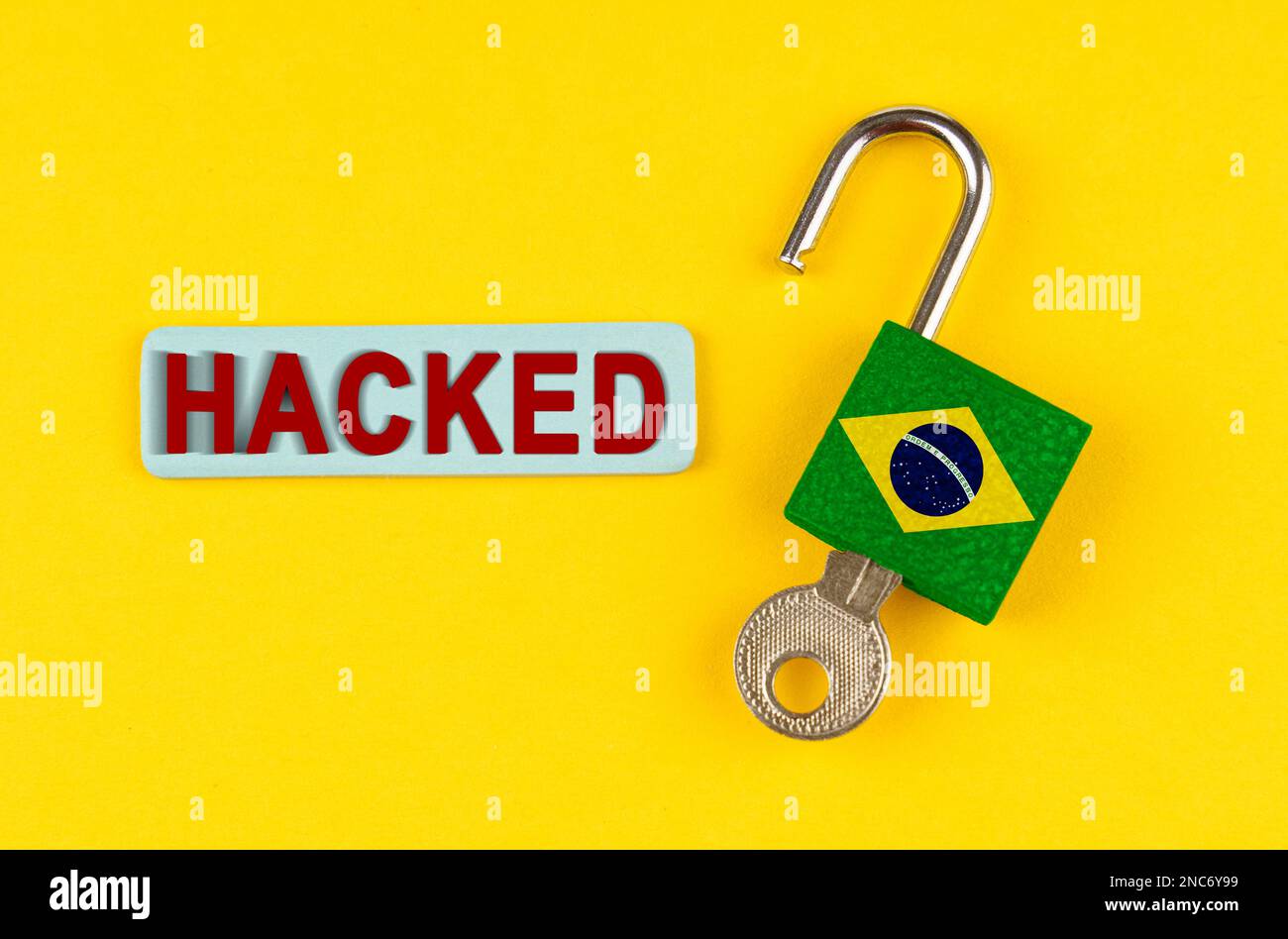 On a yellow surface, an open lock with the image of the flag of Brazil ...