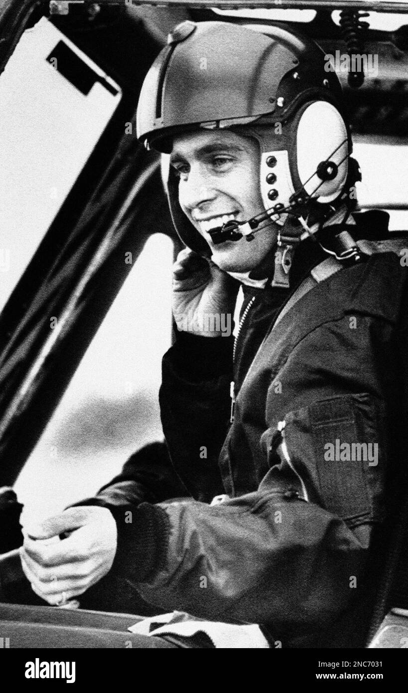Prince Andrew smiles as he puts on a helmet at the controls of a Huey ...