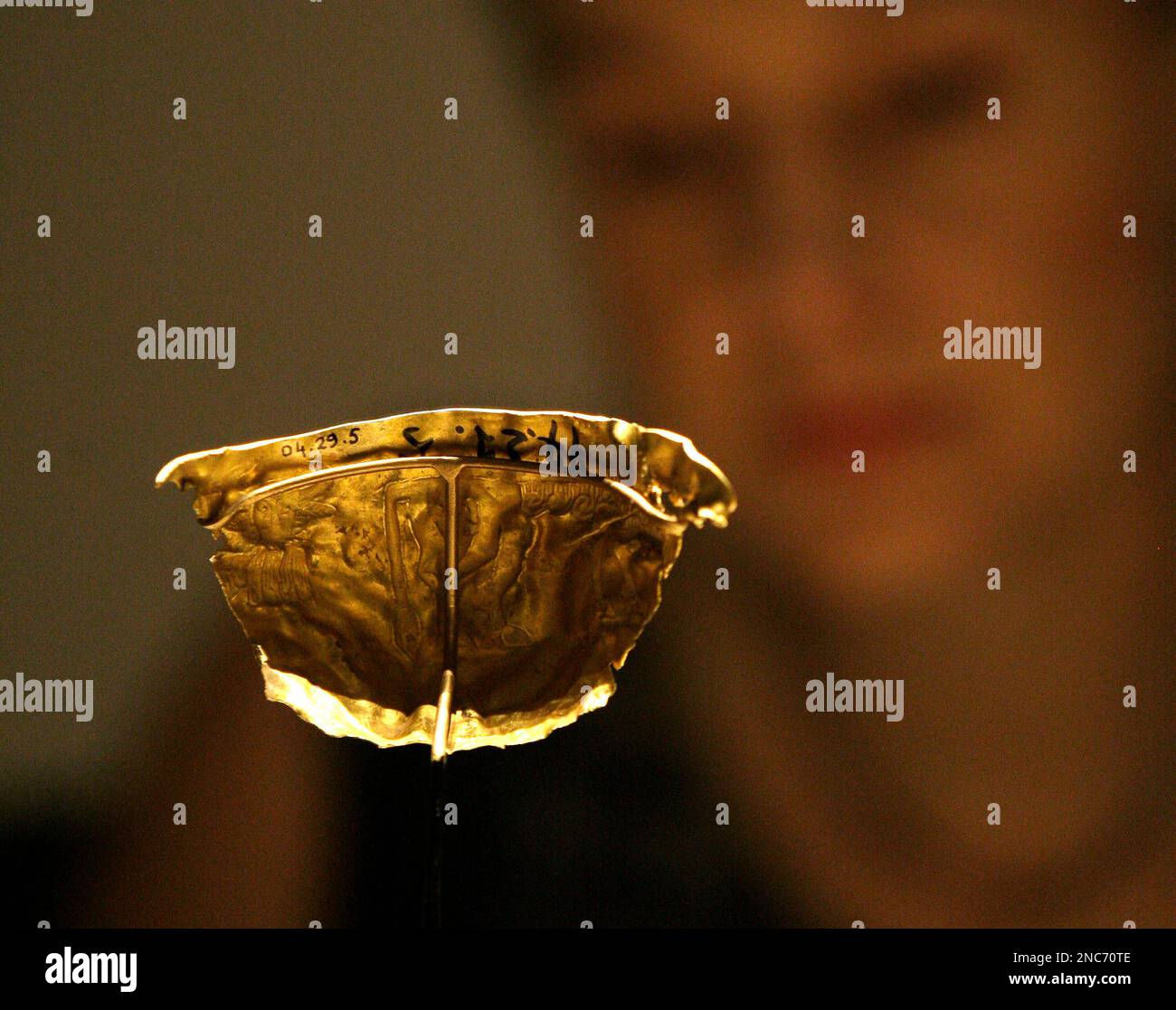 A visitor looks at a fragment from a 2200-1900 BC gold goblet ...