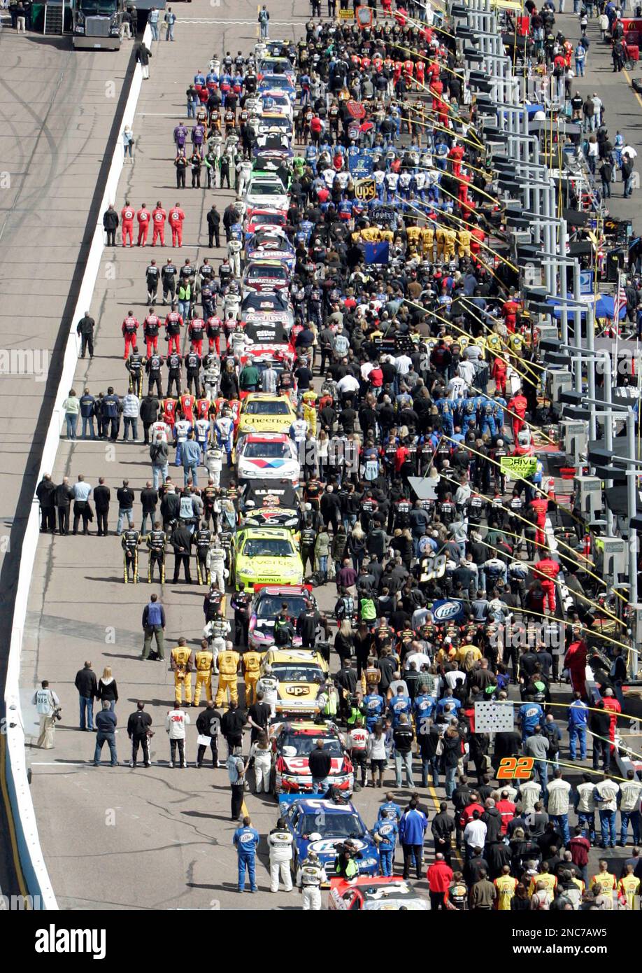 Cars and crew stand along pit row before the NASCAR Sprint Cup Series ...