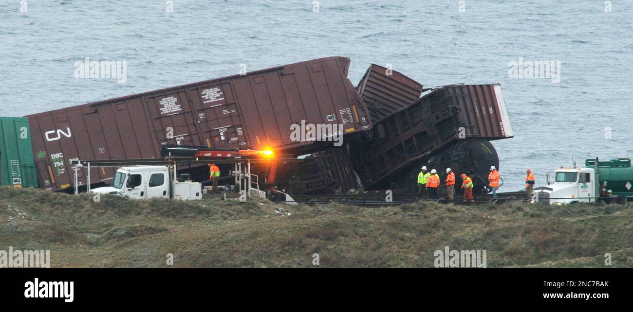 Derailed train cars, including a tanker car at lower right, are shown ...