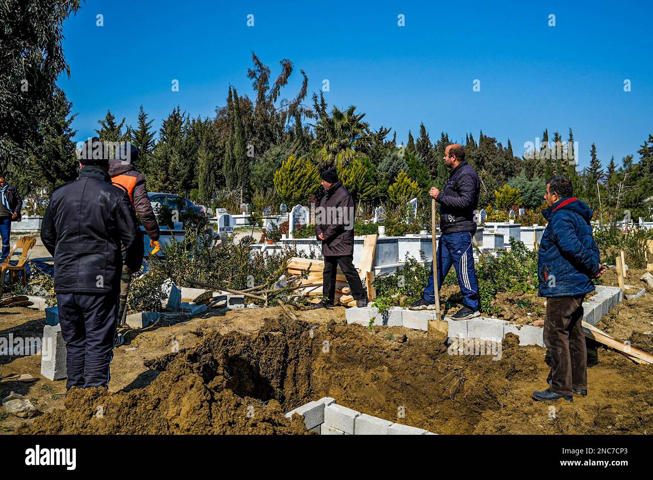 People prepare the tomb for the three children who were killed in the ...