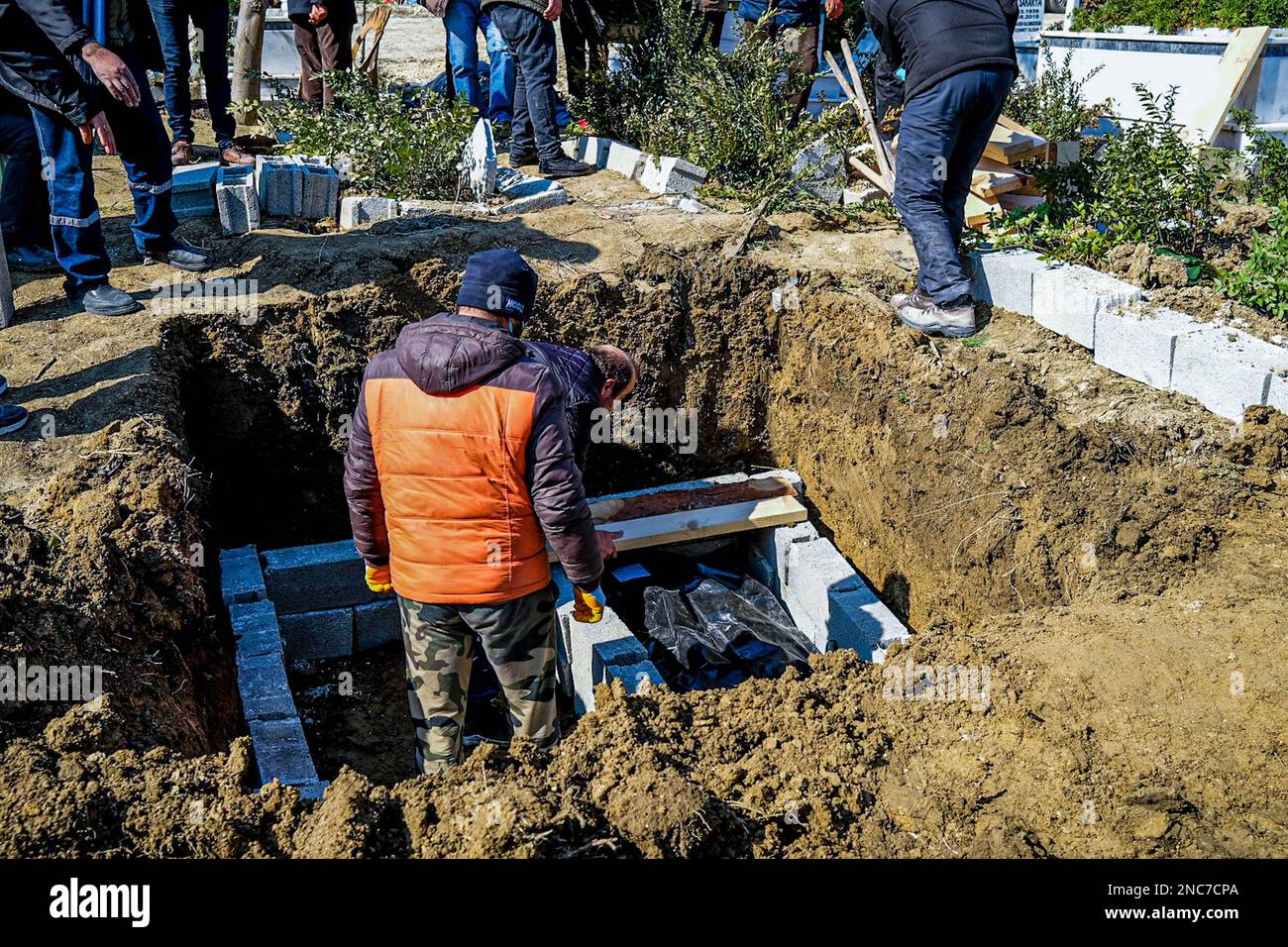People prepare the tomb for the three children who were killed in the ...