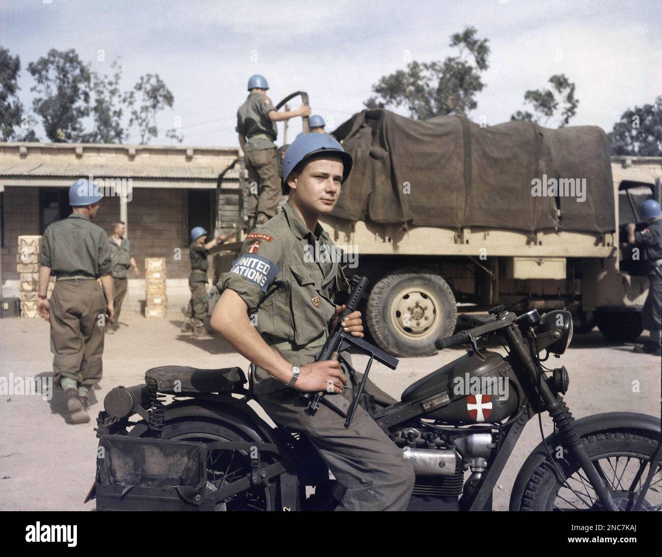 Pvt. Ole Schmiht, from Copenhagen, Denmark, on his motorcycle, stands ...