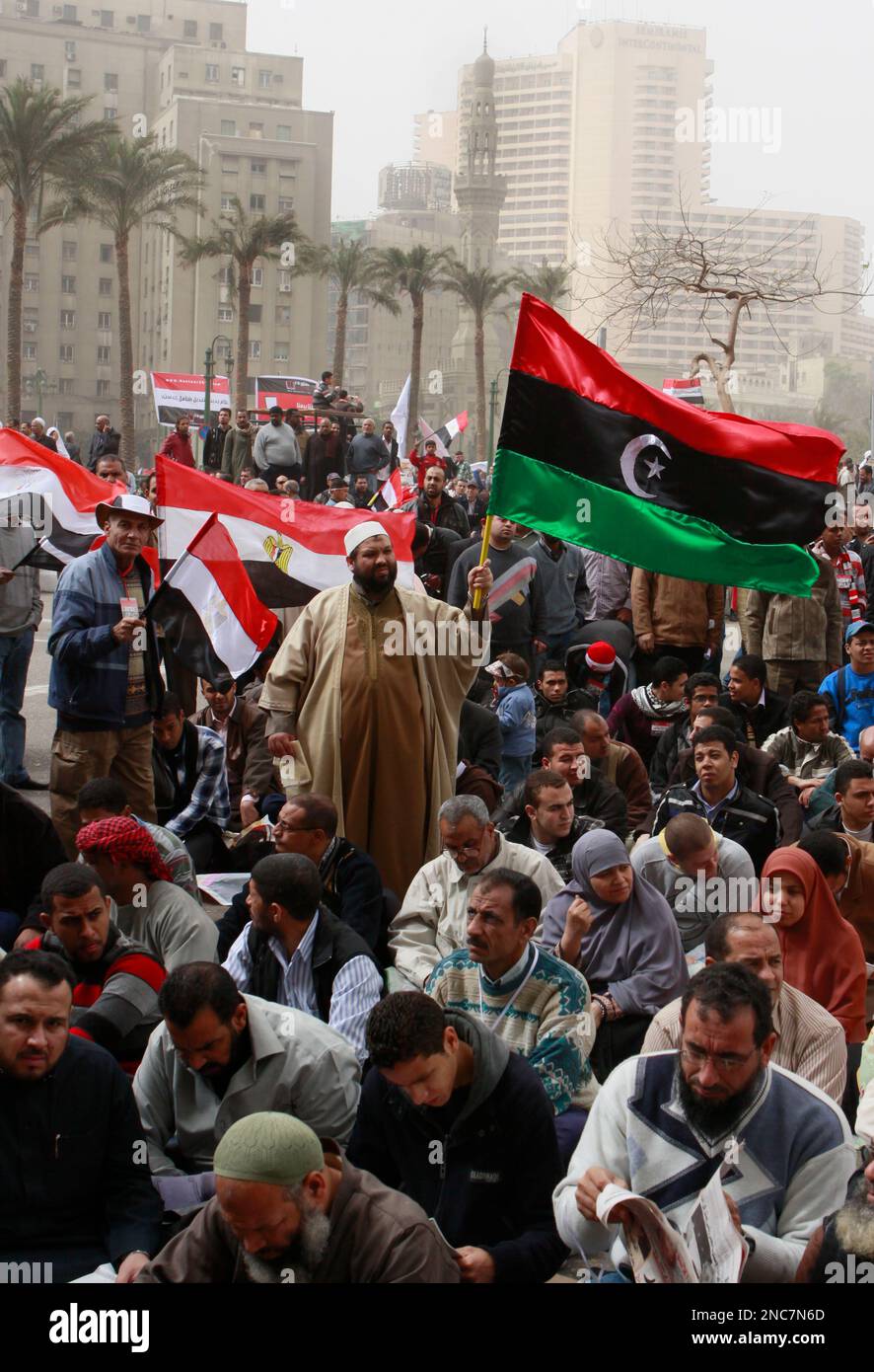 An Egyptian raise Libya's old national flag, in dupport to Libyans at ...