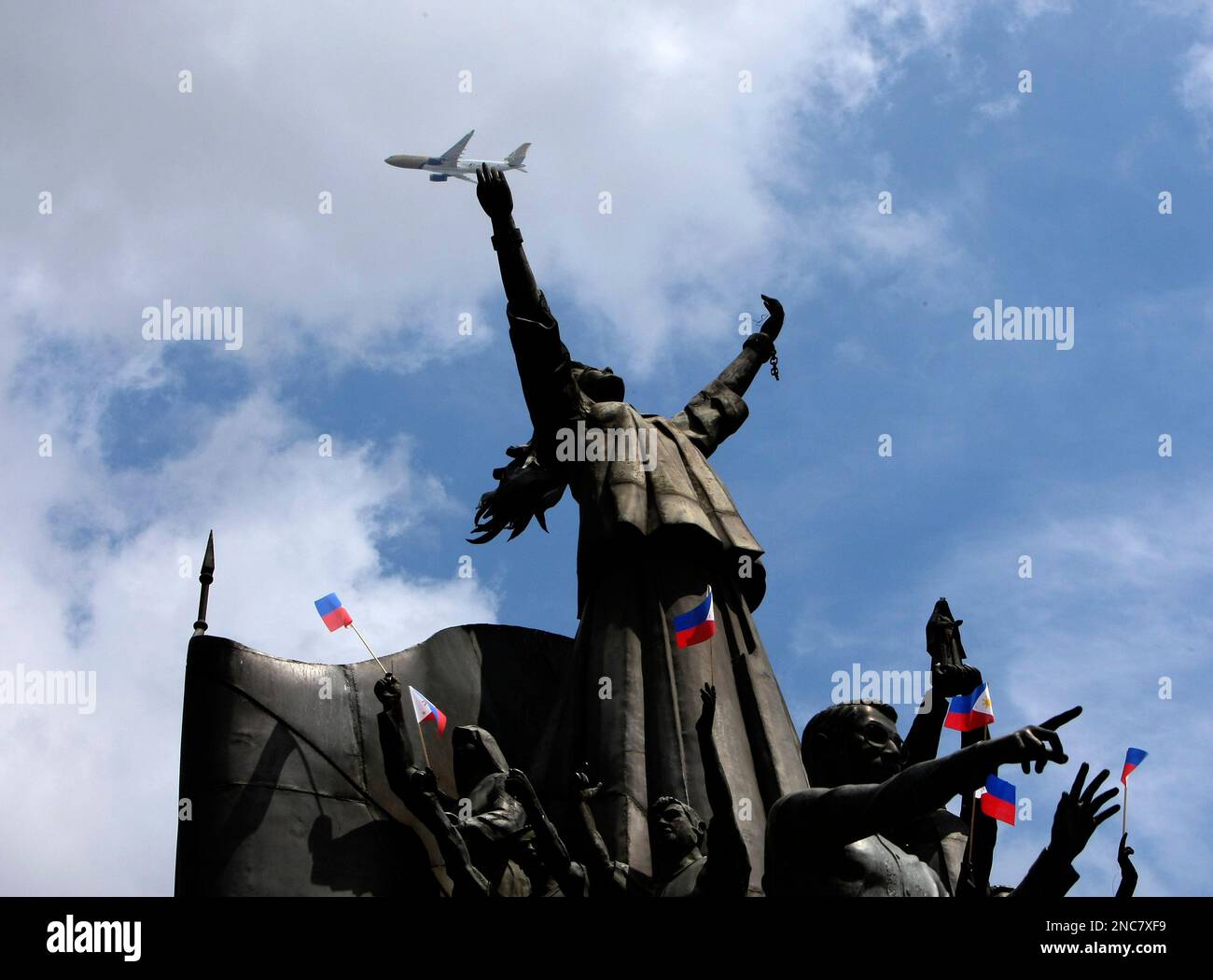 A Gulf Air passenger plane flies over the flag-decorated People Power ...