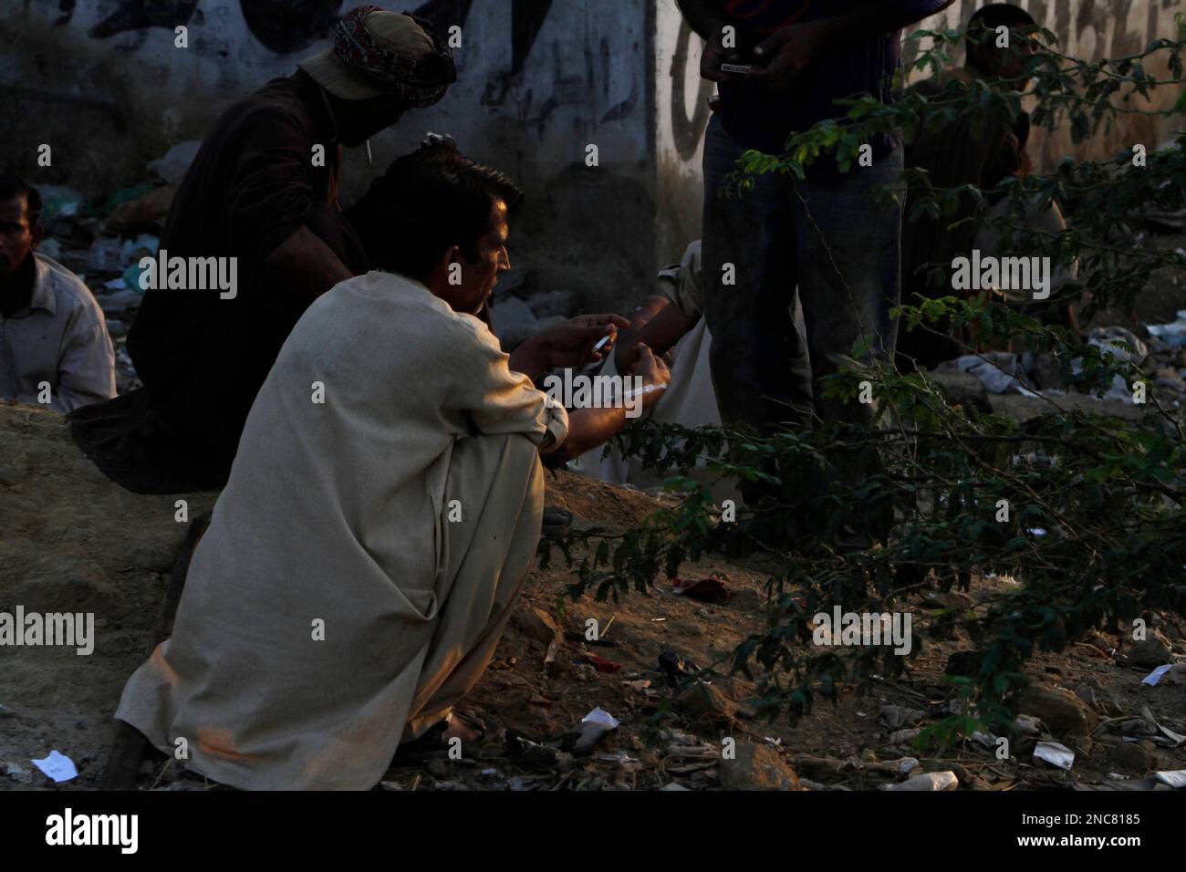 A Pakistani drug addict injects drugs, in slums of Karachi, Pakistan on ...