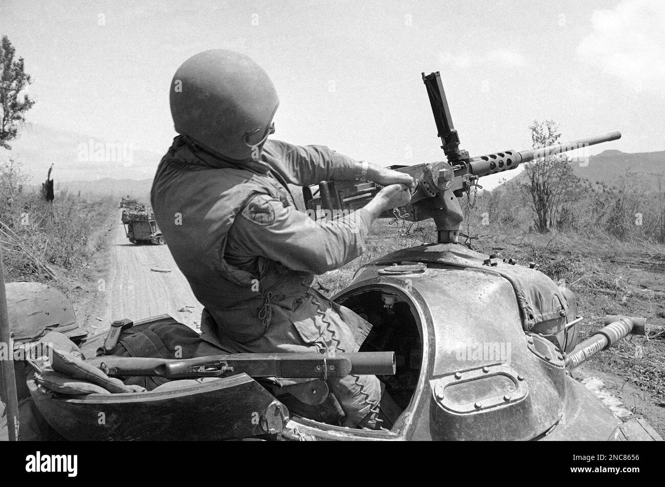 An American soldier struggles with a 50-cal. machine gun atop a tank ...