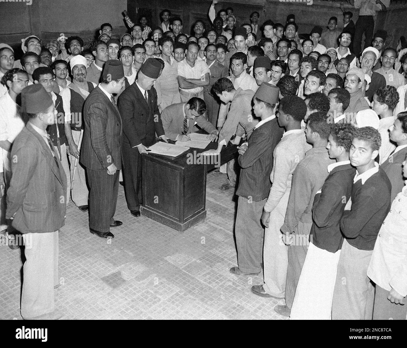 A long line of Arab volunteers crowds around desk as Leader of ...