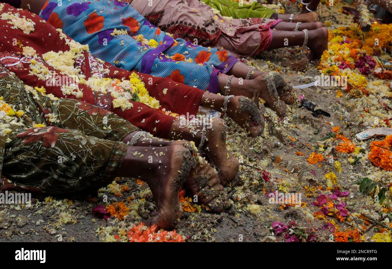 Indian Hindu women prostrate themselves, as they offer prayers at the ...
