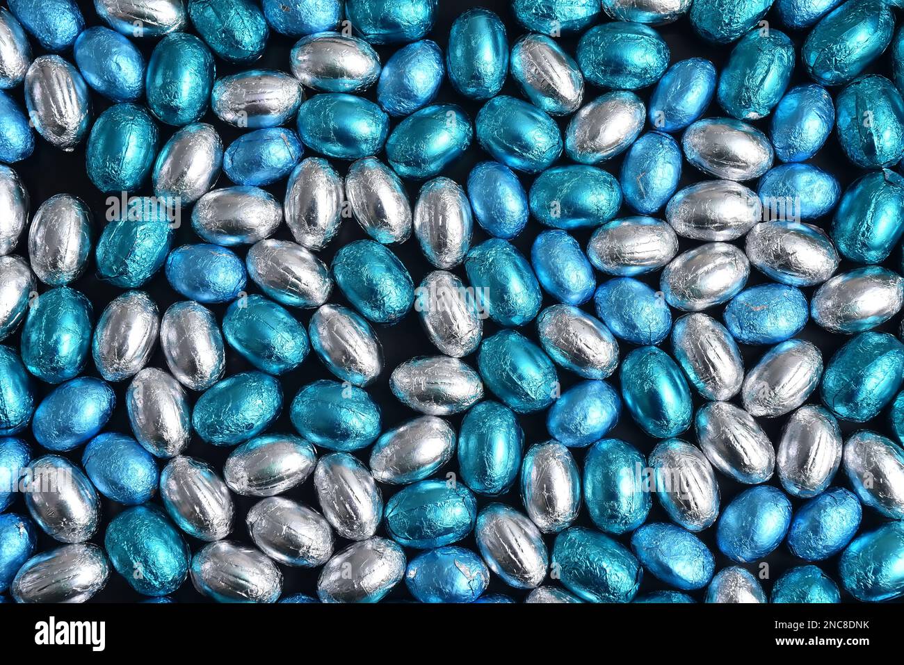 Blue, silver and turquoise foil wrapped chocolate easter eggs, against ...