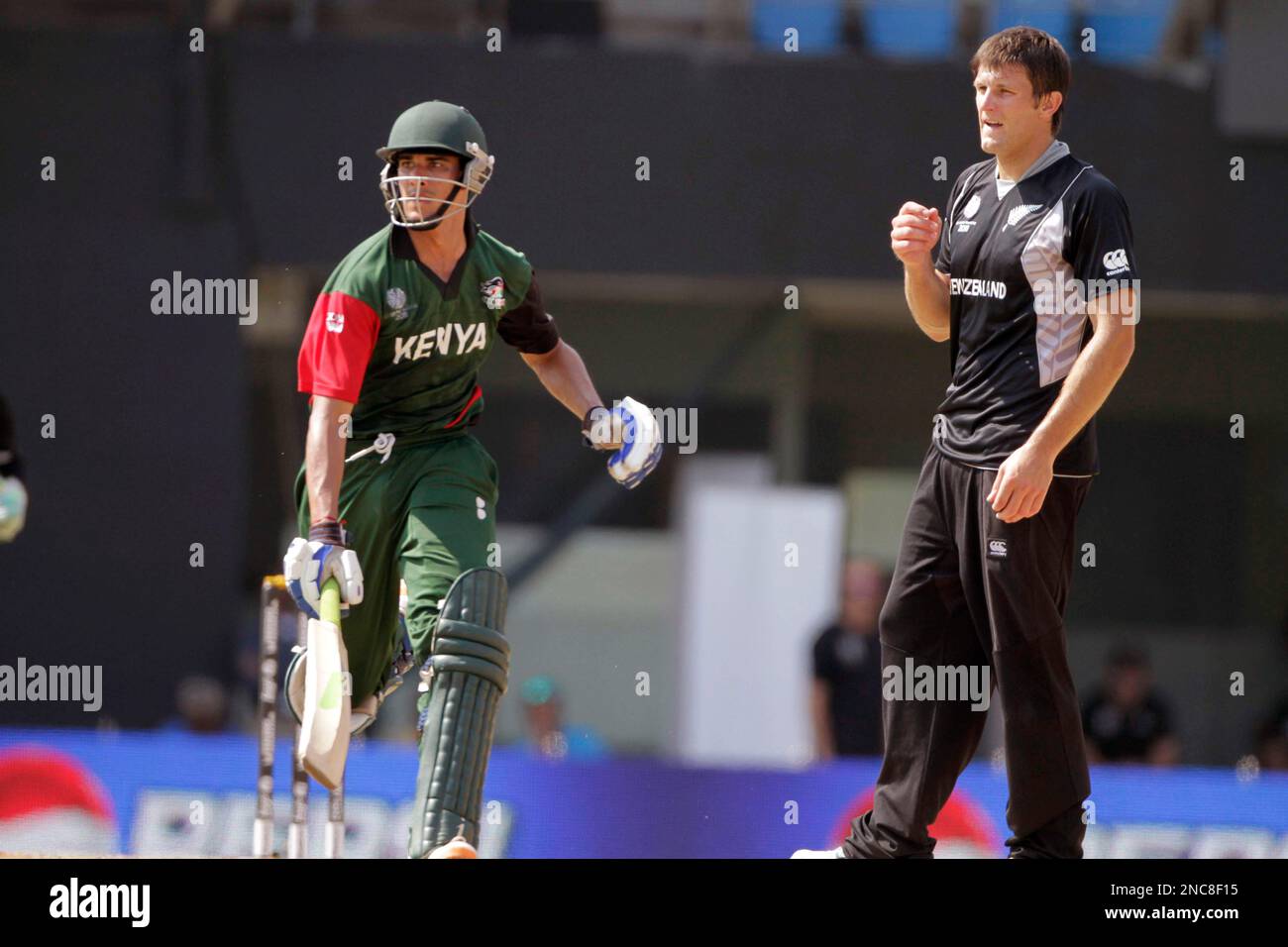 Kenya's Serene Water, left takes a run as New Zealand's Hamish Bennett ...