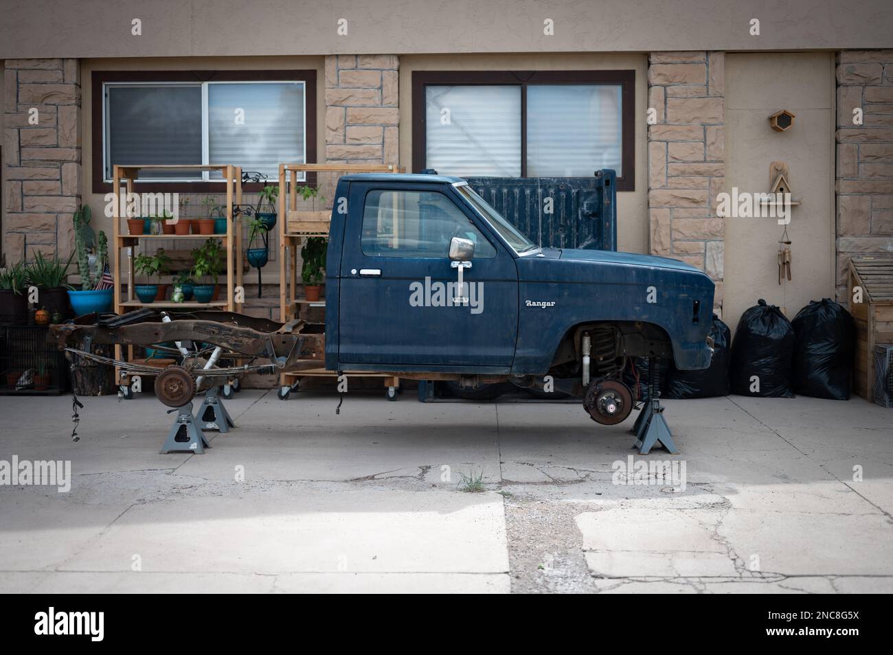 An old blue pickup truck in the process of restoration without wheels ...
