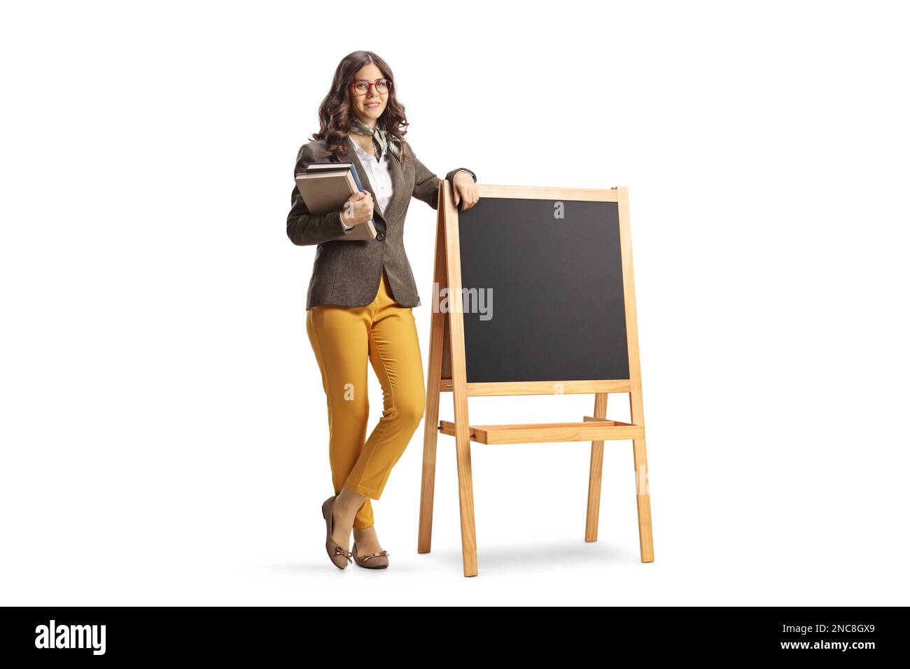 Full length portrait of a young female teacher holding books and ...