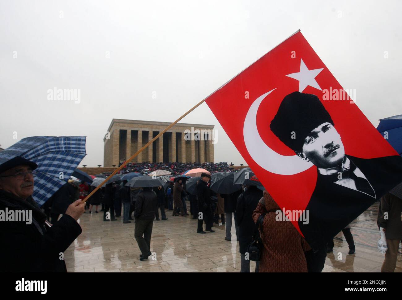 A man waves a national flag with a photo of modern Turkey's founding father Mustafa Kemal ...