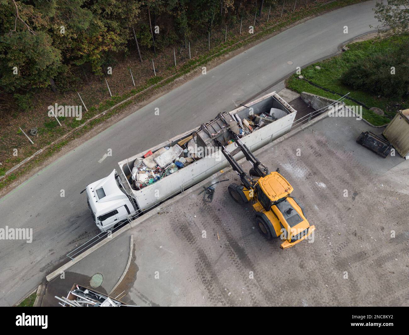 Waste loading operation, loader dumping trash in a truck on a site for ...