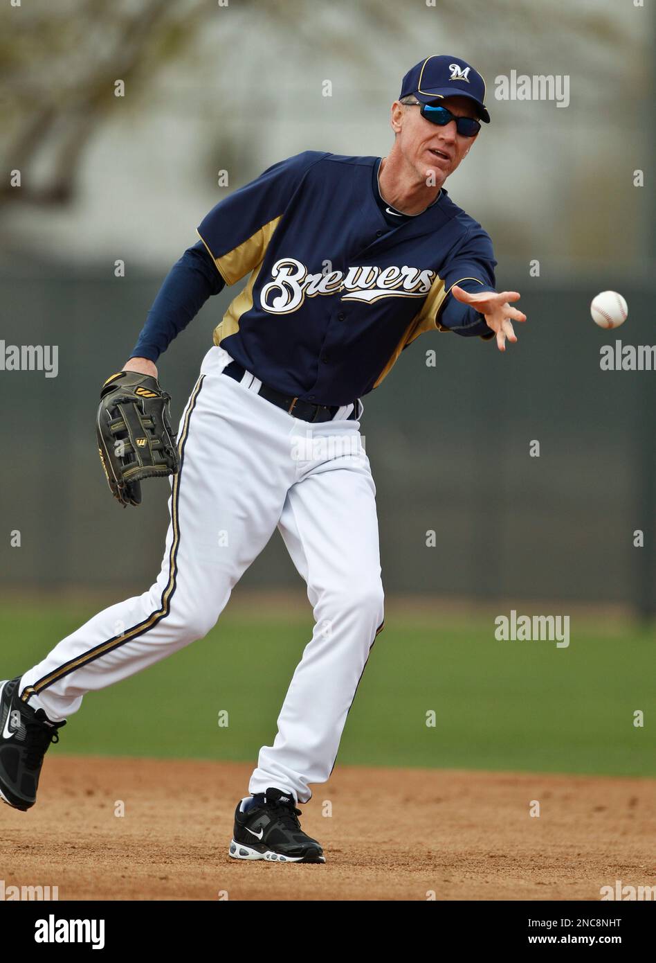 Milwaukee Brewers manager Ron Roenicke flips a ball to first base ...
