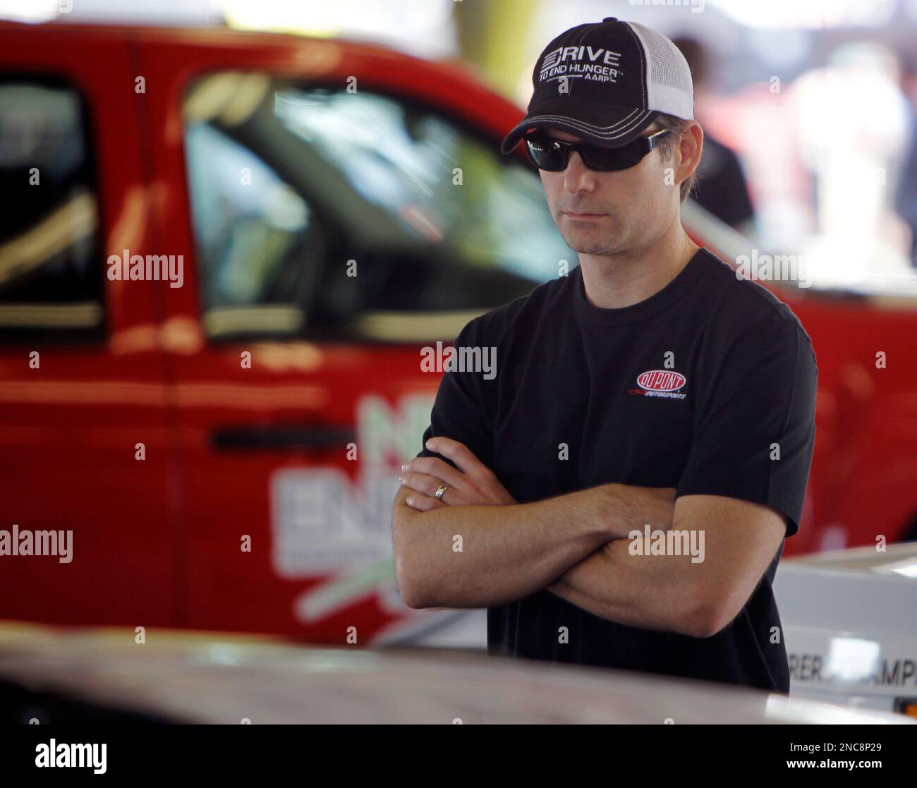 Driver Jeff Gordon looks on as crew members work on his car during ...