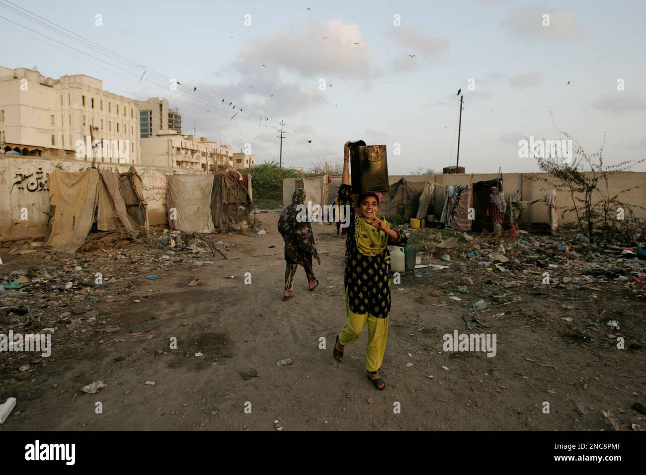 A Pakistani woman carries water in the slums of Karachi, Pakistan on ...