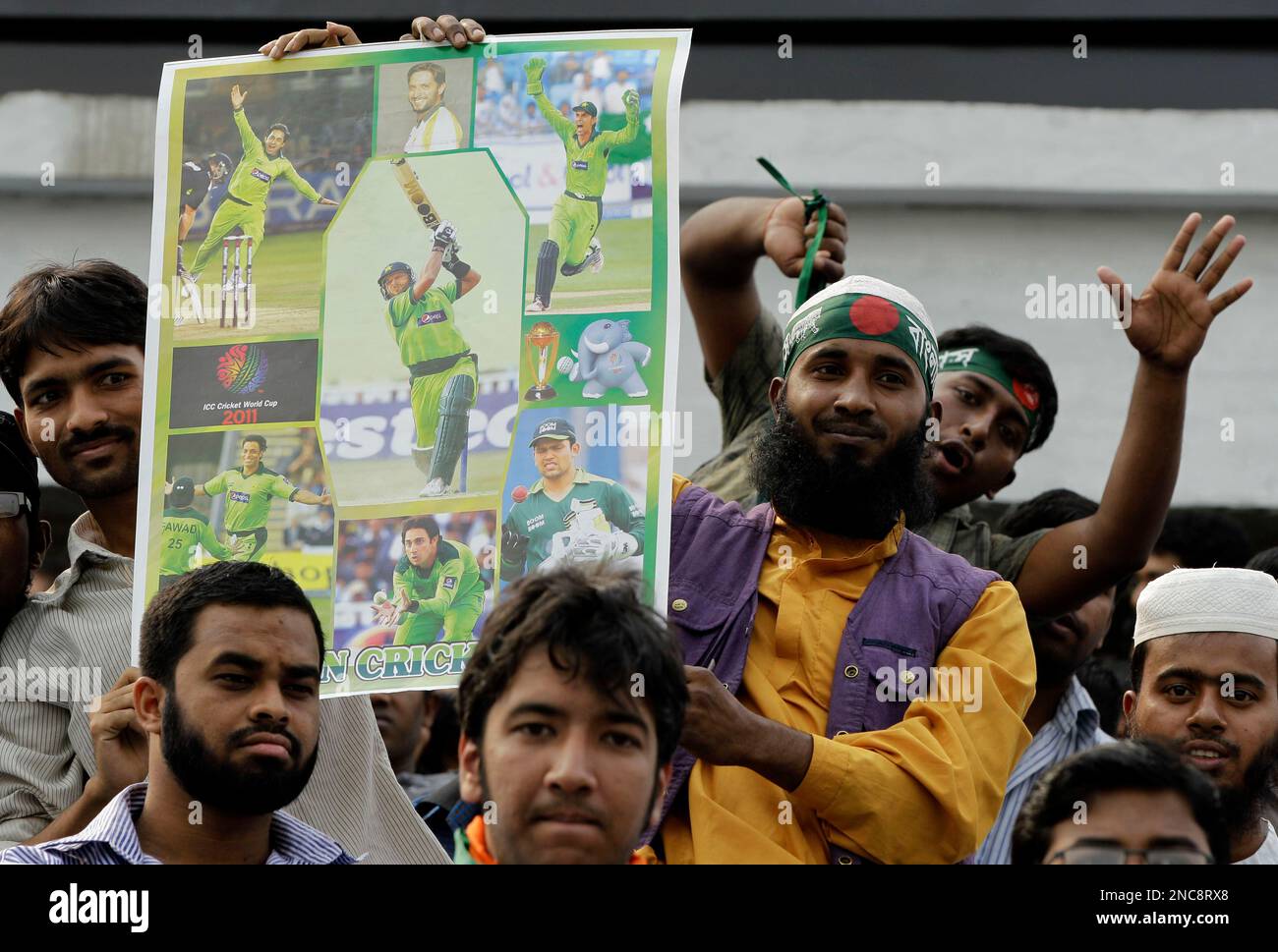 Cricket fans hold a poster depicting Pakistani players during a World ...