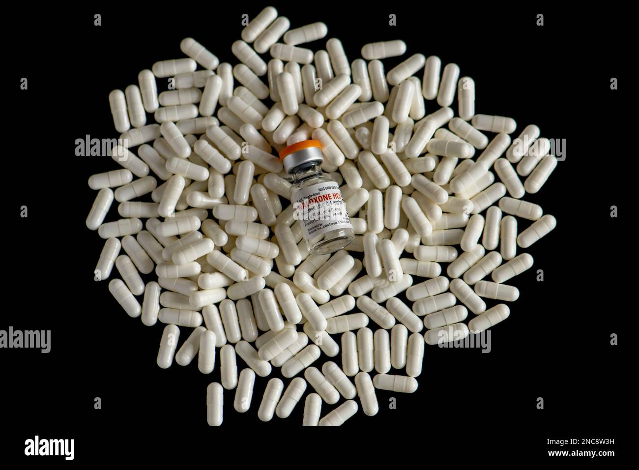 A bottle of Naloxone on a pile of pills on black background. Naloxone ...