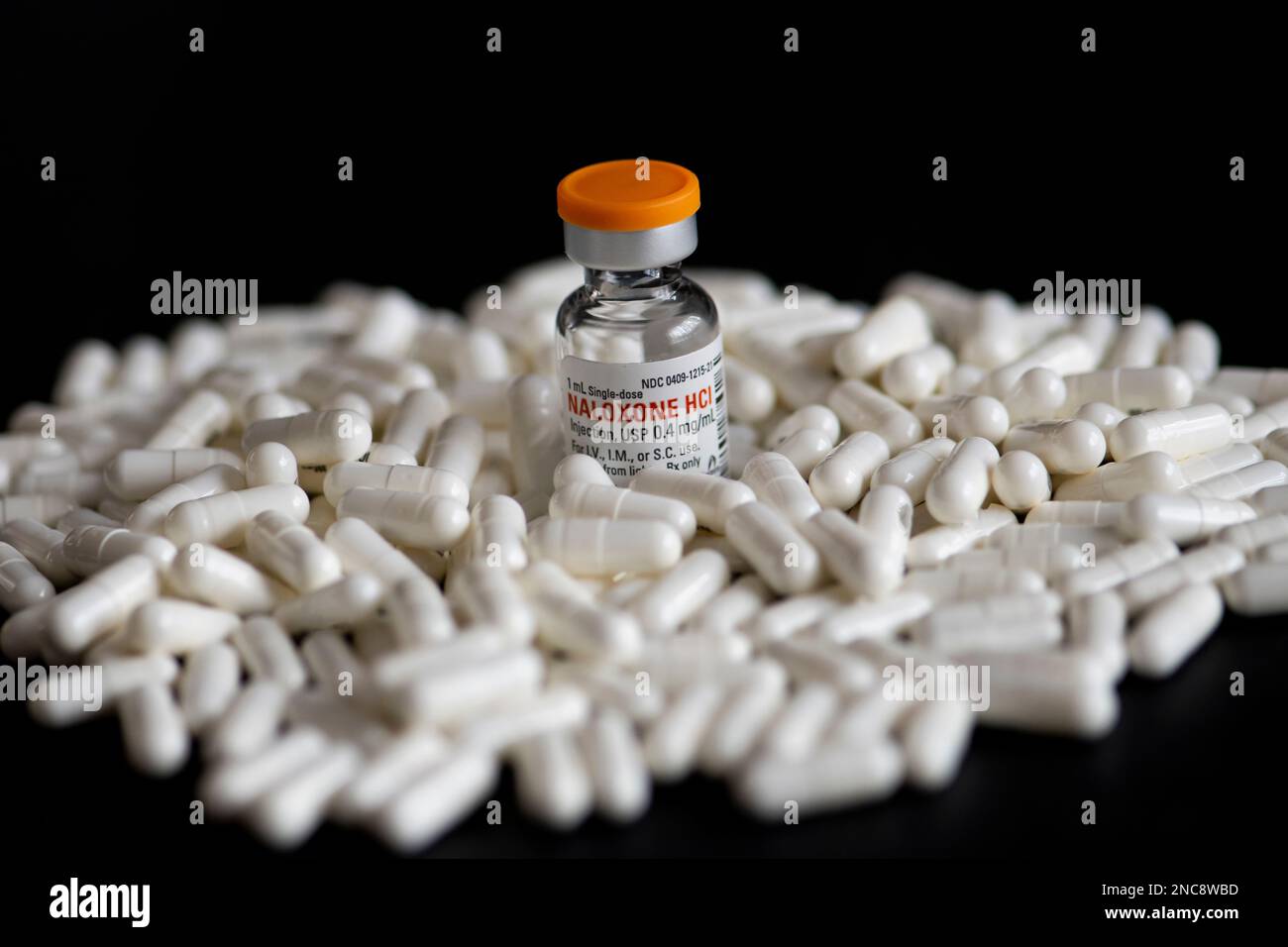 A bottle of Naloxone on a pile of pills on black background. Naloxone ...