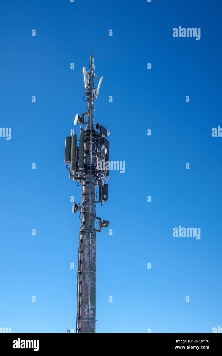 a radio mast with many antennas for mobile radio stands in the alps in ...