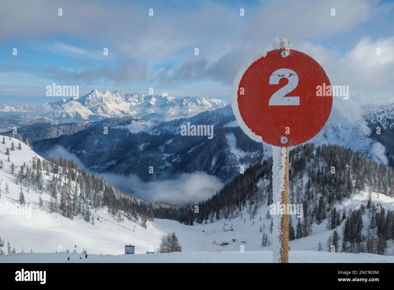 an icy red sign marks a red slope in the ski area Stock Photo - Alamy