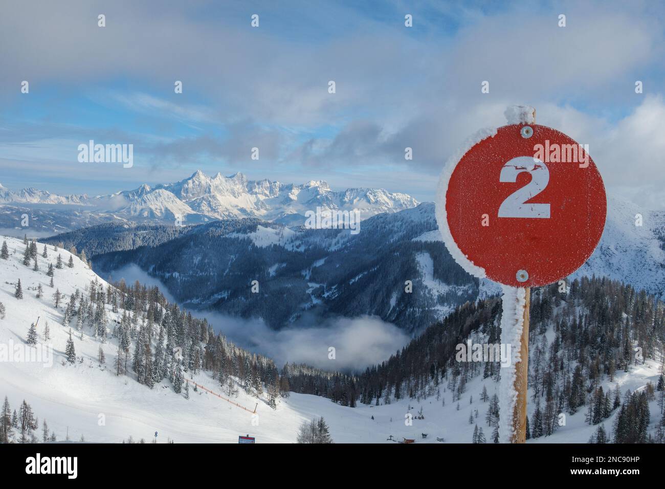 an icy red sign marks a red slope in the ski area Stock Photo - Alamy