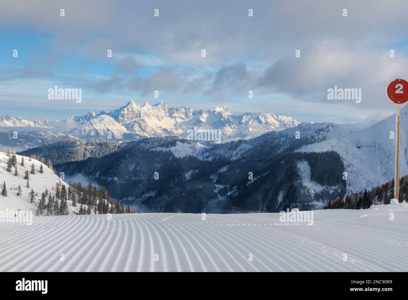 an icy red sign marks a red slope in the ski area Stock Photo - Alamy