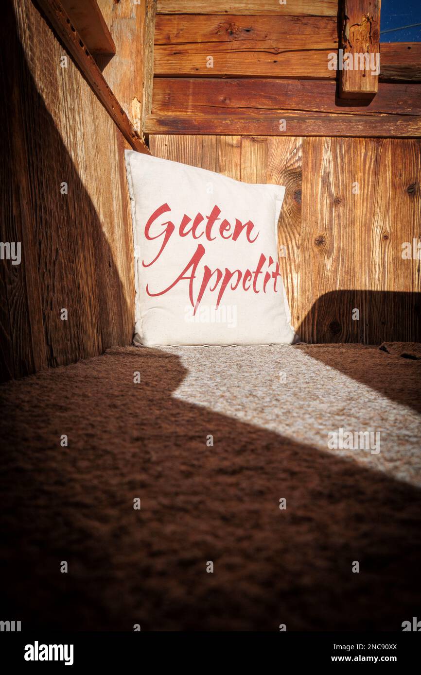 on a white cushion on a bench are the german words Guten Appetit Stock ...